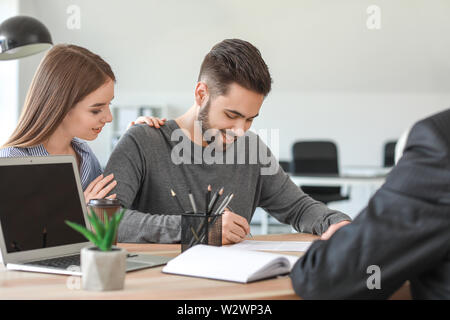 Couple signing documents at notary public office Stock Photo - Alamy