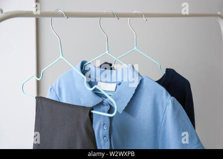 Rack with stylish school uniform on white background Stock Photo - Alamy