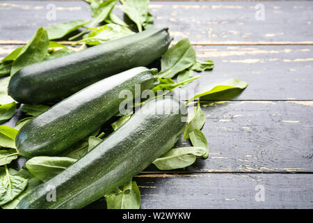 Fresh zucchini squashes on wooden background. Ugly zucchini in two ...