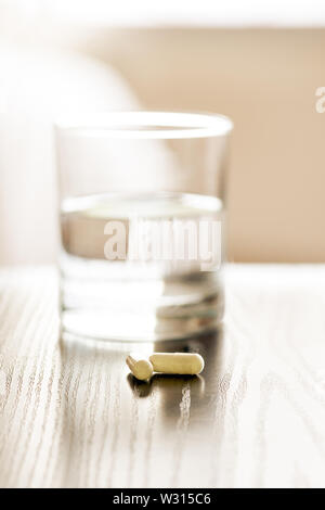 Medication next to a glass of water Stock Photo - Alamy