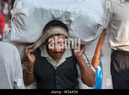 Man carrying a heavy load of goods on his back in Istanbul Stock Photo ...