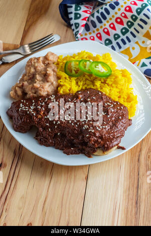 Chicken Mole dish with rice and beans on a Mexican handmade bowl with ...