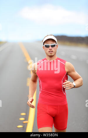 Young professional male triathlete, runner in motion on open road ...