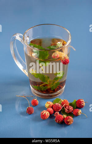 A ripe strawberry is scattered on a blue wooden table. place for text ...