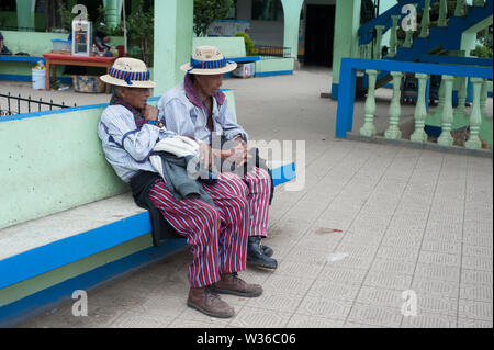 Men in traditional Mayan clothing take part in a ceremony at a festival ...