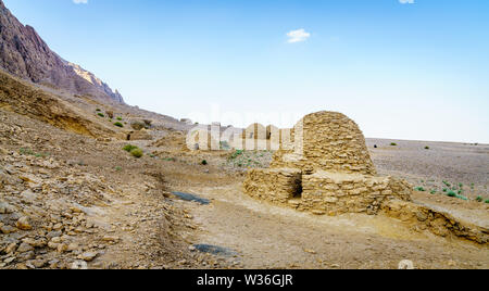 Ancient stone beehive tombs with Jebel Misht mountain in the background ...