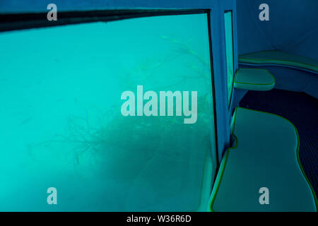 Underwater view of bottom of boat looking up through Snell's window ...