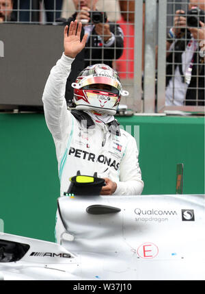 Mercedes driver Lewis Hamilton waves to fans as he arrives at the track ...