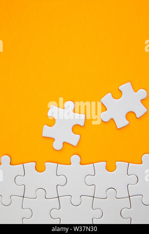 Jigsaw puzzle pieces on orange background Stock Photo - Alamy
