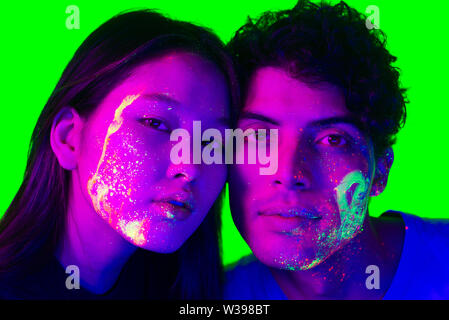 Portrait of fashionable man with colored fluo painting on the face ...