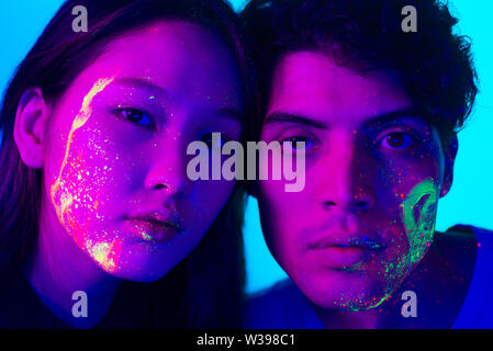Portrait of fashionable man with colored fluo painting on the face ...
