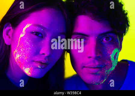 Portrait of fashionable man with colored fluo painting on the face ...