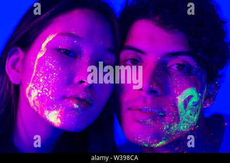 Portrait of fashionable man with colored fluo painting on the face ...