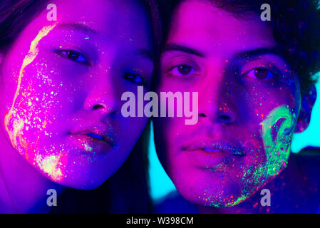 Portrait of fashionable man with colored fluo painting on the face ...
