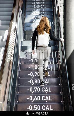Stairs to a gym, next to an escalator, each step is listed with ...