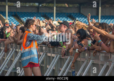 volunteer handing out water at a Festival Stock Photo - Alamy