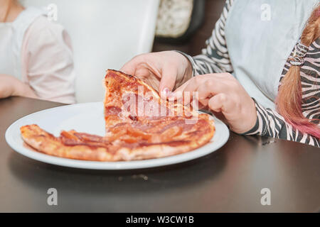 close up. small participants of the master class eat pizza . cooking ...