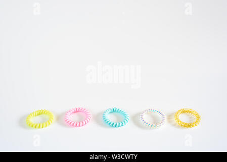Plastic bracelets of various colors, isolated in a pattern arranged in ...