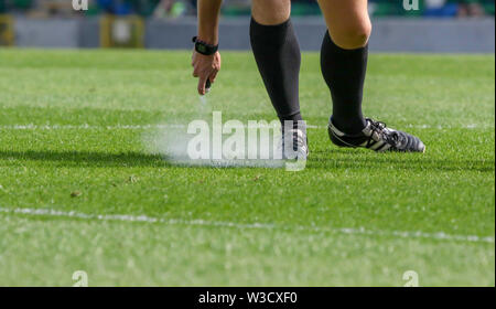 Soccer referee with foam spray, spraying the surface of a football ...