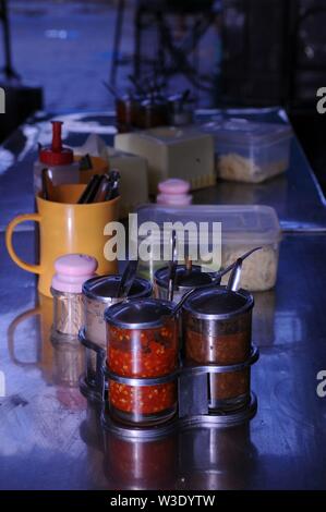 condiments & spices on an open air local restaurant table, including ...