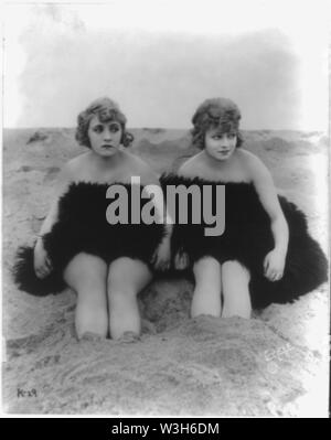 Claire Anderson and Rose Carter, seated on a beach in fur garments ...