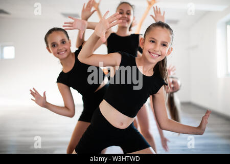 Group of fit happy children exercising ballet in studio together Stock ...