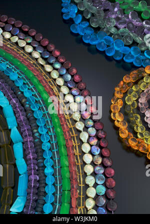Different colorful beads on purple background Stock Photo - Alamy