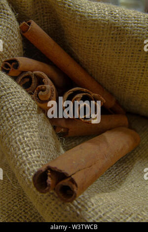 Aromatic cinnamon sticks on burlap fabric, closeup Stock Photo - Alamy