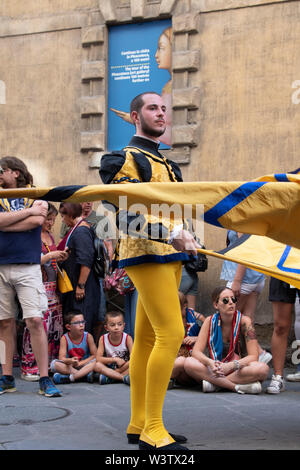 A young man waves a flag representing his contrada, also known as a ...