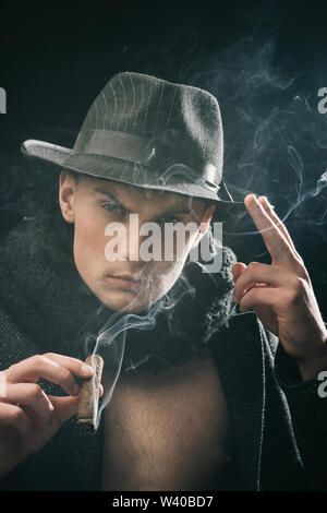 Private detective in old fashion hat smokes a cigarette. Gangster Stock ...