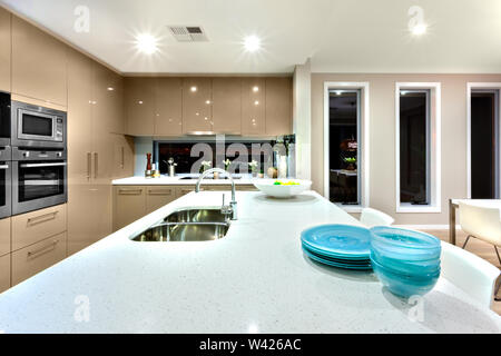 Sink and tap installed on counter under black cupboards inside ...