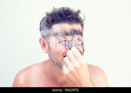 Young man applying mask on face at home Stock Photo - Alamy