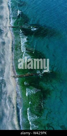 Vertical overhead shot of the beautiful shoreline of the sea with blue ...