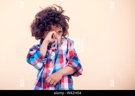 Sad kid with curly hair cry over isolated background Stock Photo - Alamy