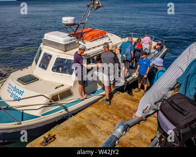 A group of tourists boarding the Gower Ranger boat on RSPB Ramsey ...