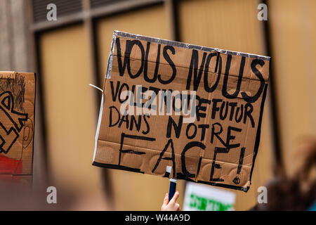 A closeup view of a cardboard French poster, saying save the earth more ...