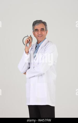 A doctor wears a lab coat and stethoscope in an exam room at a health ...