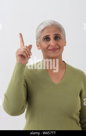 Elderly hand pointing upward with index finger, signaling attention and ...