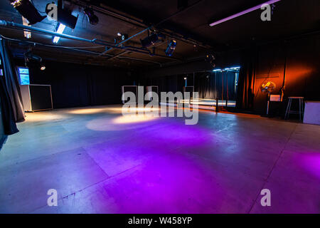 A large and empty dance studio room with mirrored wall and wooden floor ...