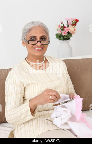Portrait of a woman doing embroidery Stock Photo - Alamy