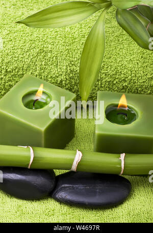 Spa stones with towel, candles, bamboo and pink orchid on wooden ...