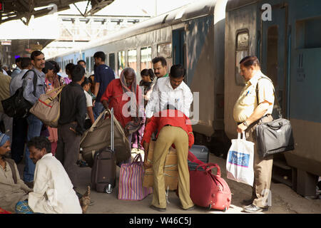 Coolie carrying passengers luggage at a platform Stock Photo - Alamy