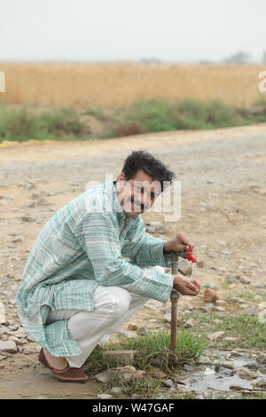 Thirsty man farmer drinking water from bottle in the garden during ...