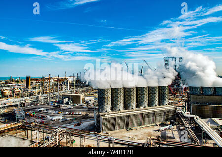Cooling towers inside a refinery emit steam Stock Photo - Alamy
