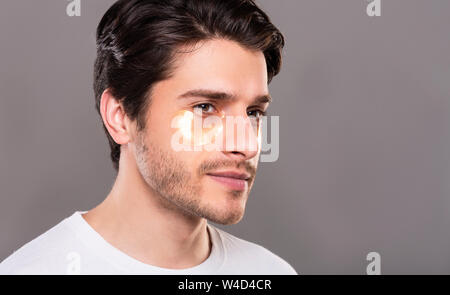Handsome man with golden patch under eyes. Beauty studio. Spa salon ...