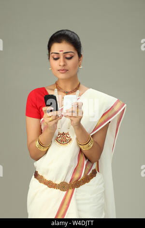 South Indian woman text messaging and smiling Stock Photo - Alamy