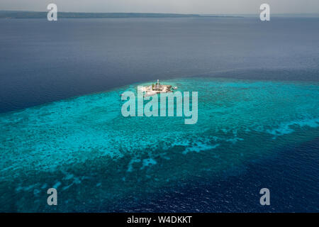 Aerial view of a huge coral reef table forming a fringing reef around a ...