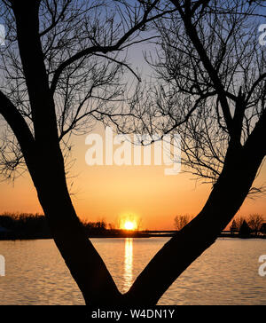 Beautiful orange sunset behind silhouette of low mountains and blue ...