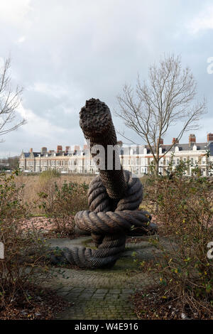 Metal rope knot sculpture artwork in landscaped public gardens outside ...