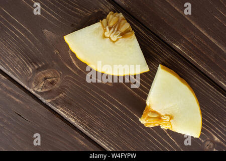 Pieces of ripe melon on a brown wooden table Stock Photo - Alamy